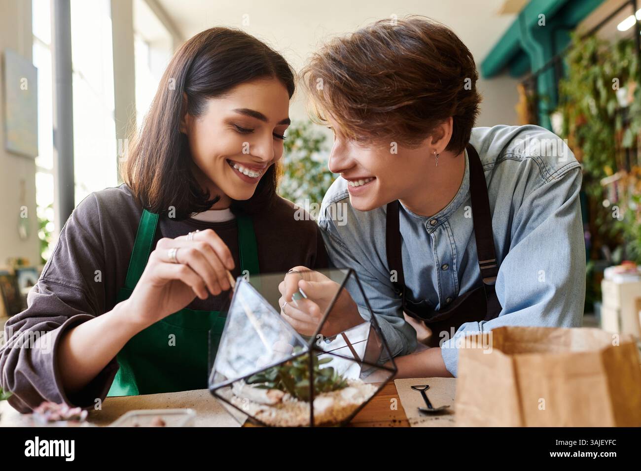 Loving couple work together in an art studio, sharing smiles as they ...
