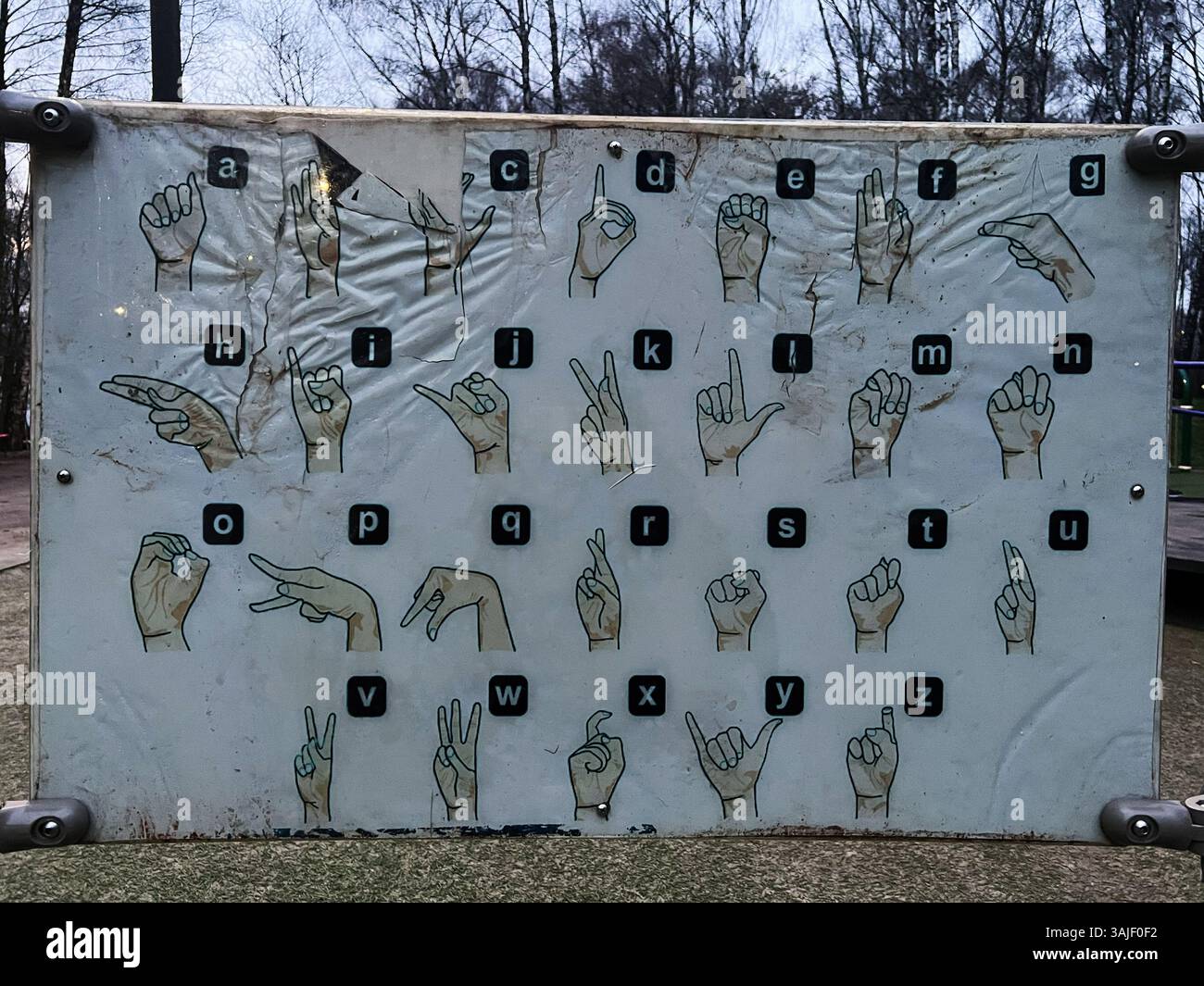 An illustrated sign language alphabet chart on a public display in open ...