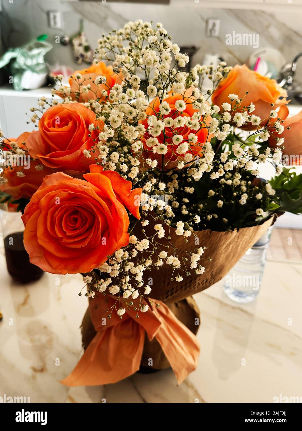 Stunning orange roses with delicate white baby's breath in a wrapped ...