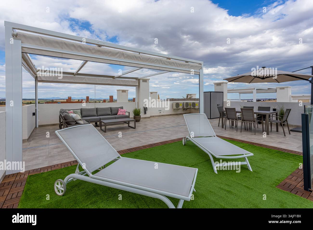 Expansive rooftop with lounge area, dining table, and artificial grass ...