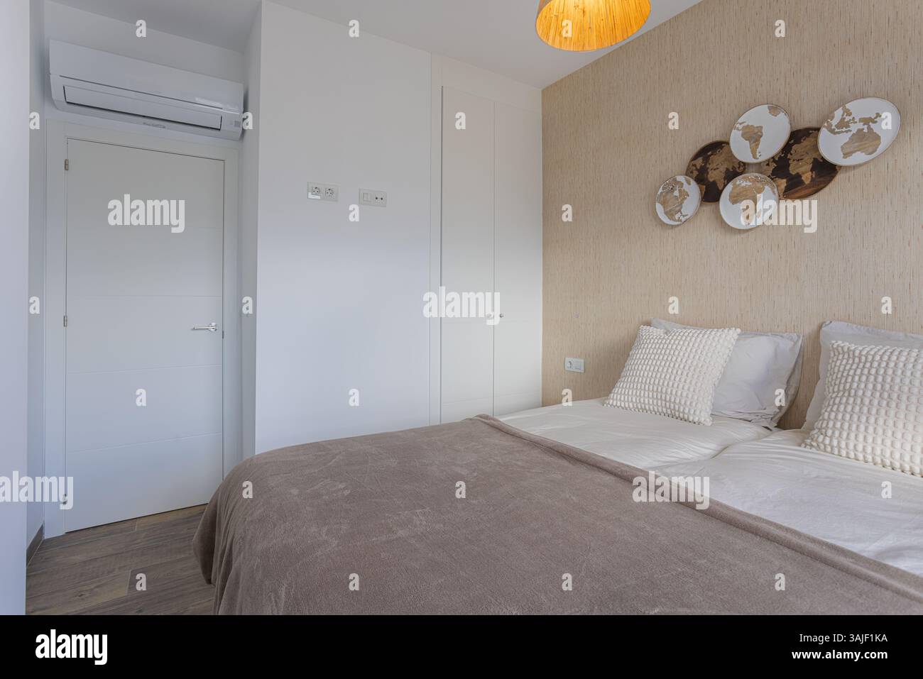 Scandinavian-inspired bedroom with white walls, soft bedding, beige ...