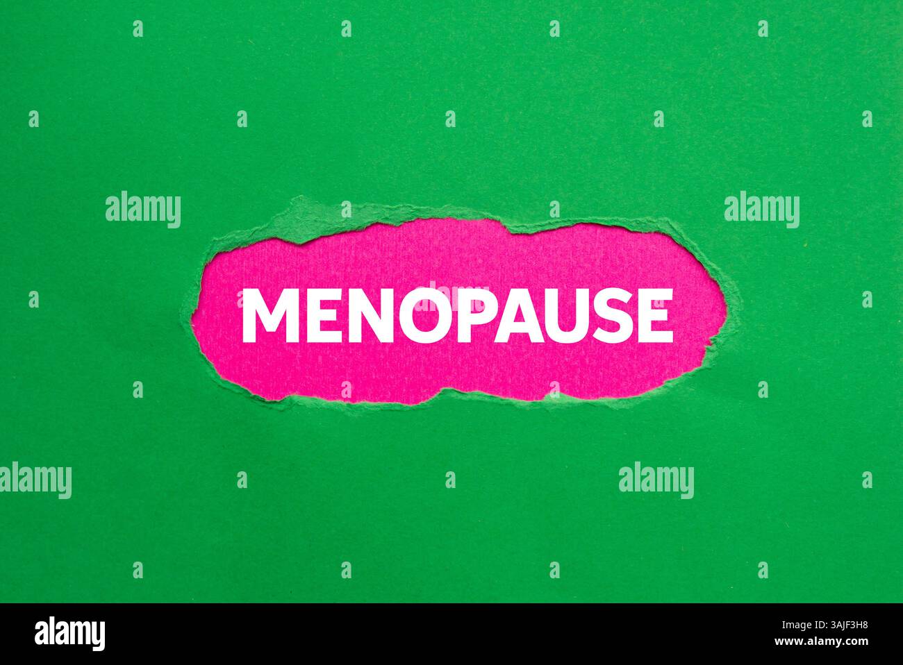 Menopause message written on ripped torn green paper on pink background ...