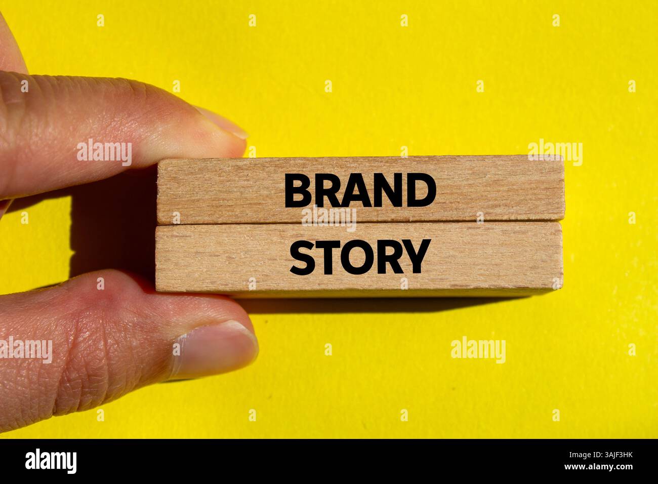 Brand story message written on wooden blocks on yellow background ...