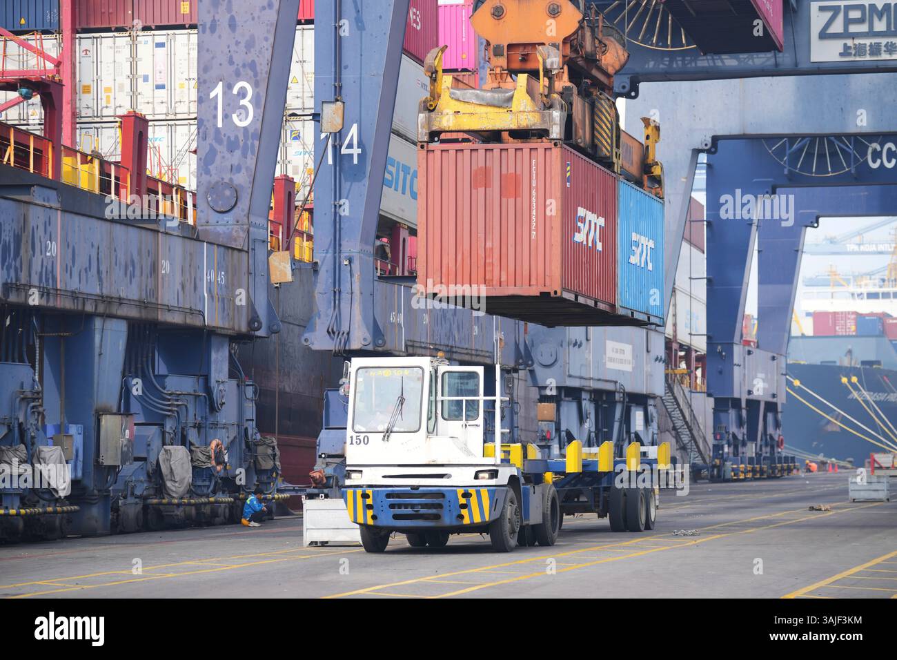 A crane unload shipping containers from a truck at Jakarta ...