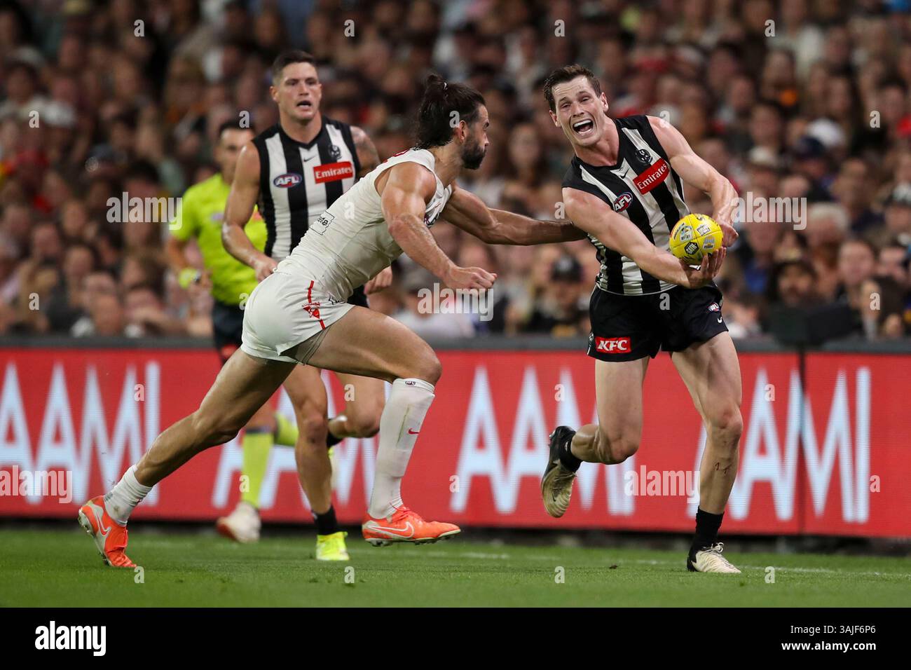 Ned Long of the Magpies is tackled by Brodie Grundy of the Swans during ...