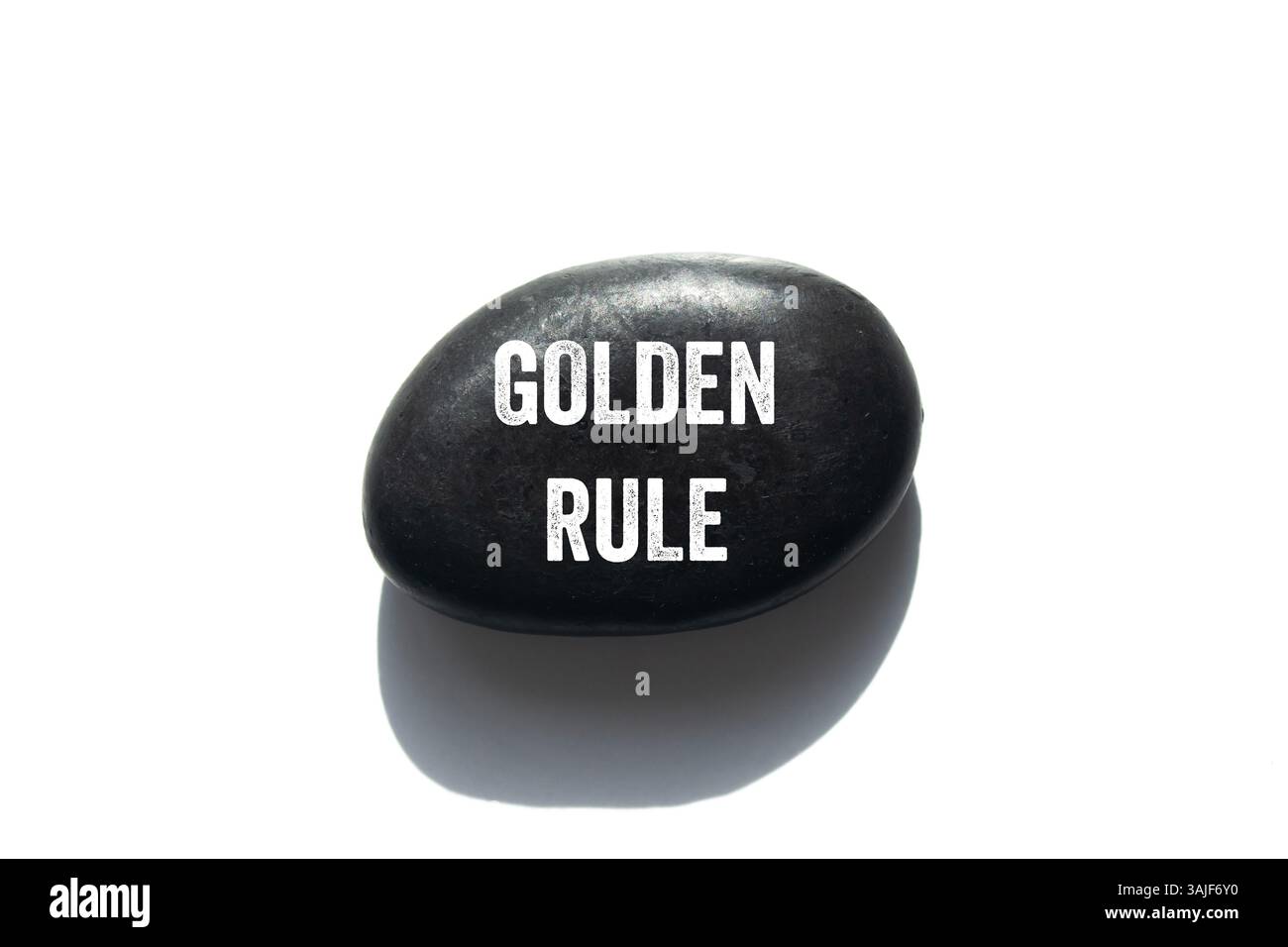 Golden rule message written on black stone on white background ...