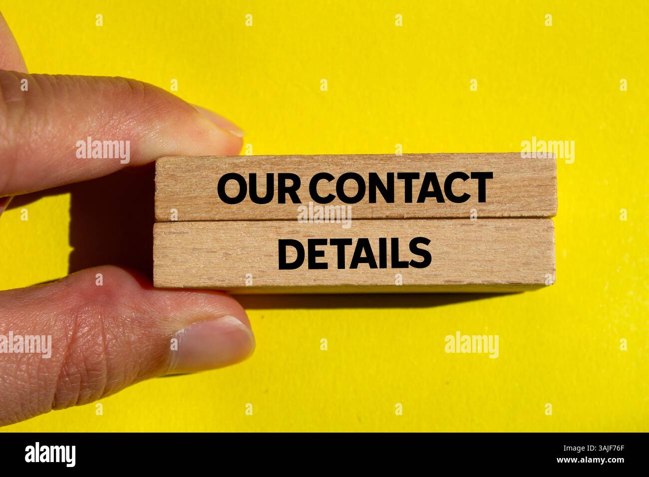 Our contact details message written on wooden blocks on yellow ...