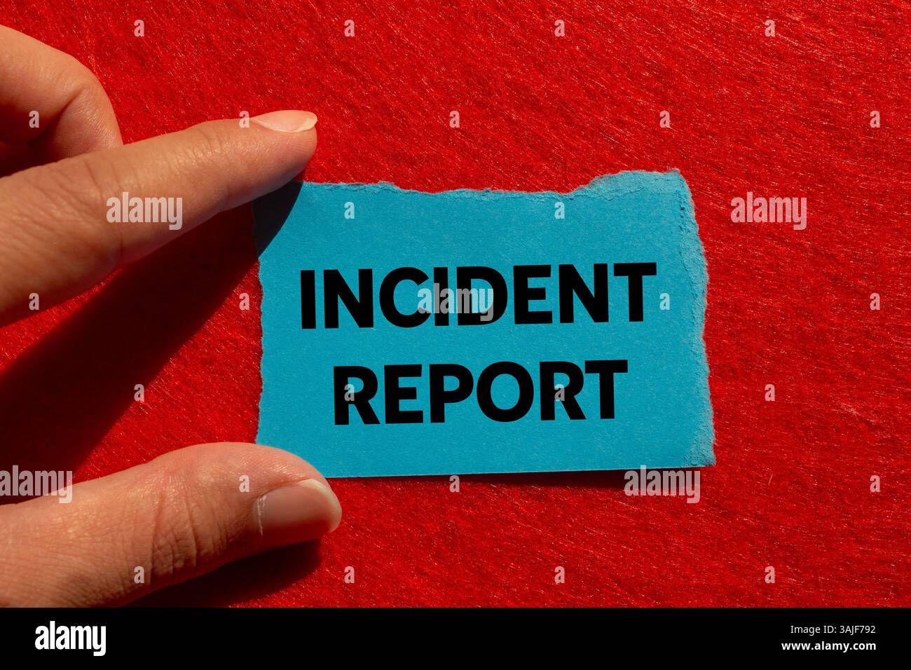 Incident report message written on ripped torn blue paper on red ...