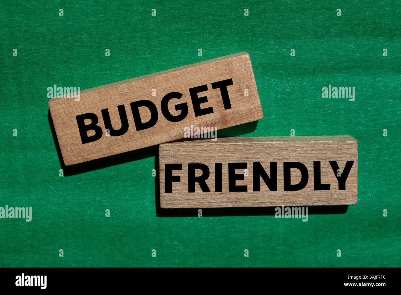 Budget friendly message written on wooden blocks on green background ...