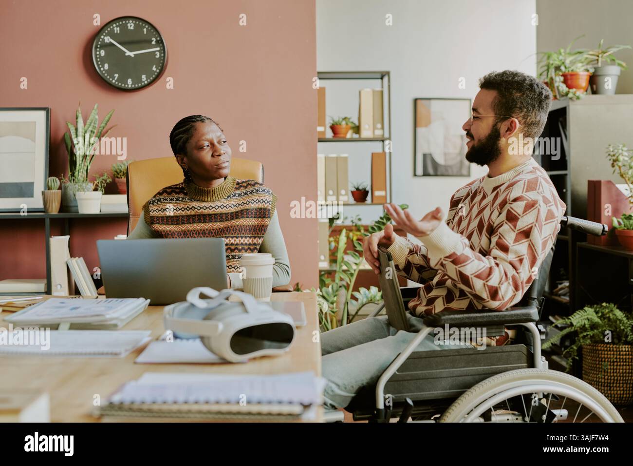 Medium shot of male programmer with disability chatting nicely with ...