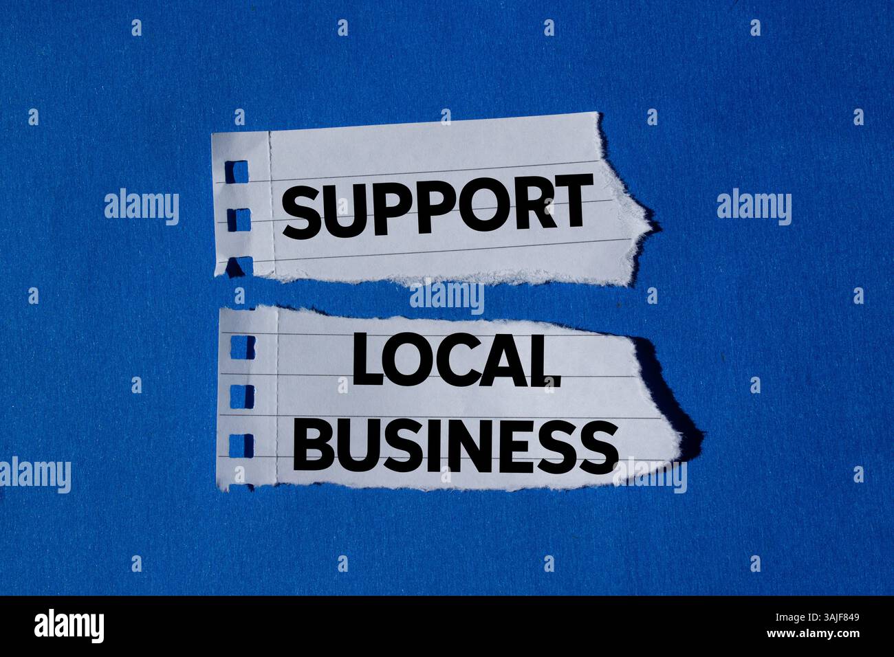 Support local business message written on ripped torn white paper ...
