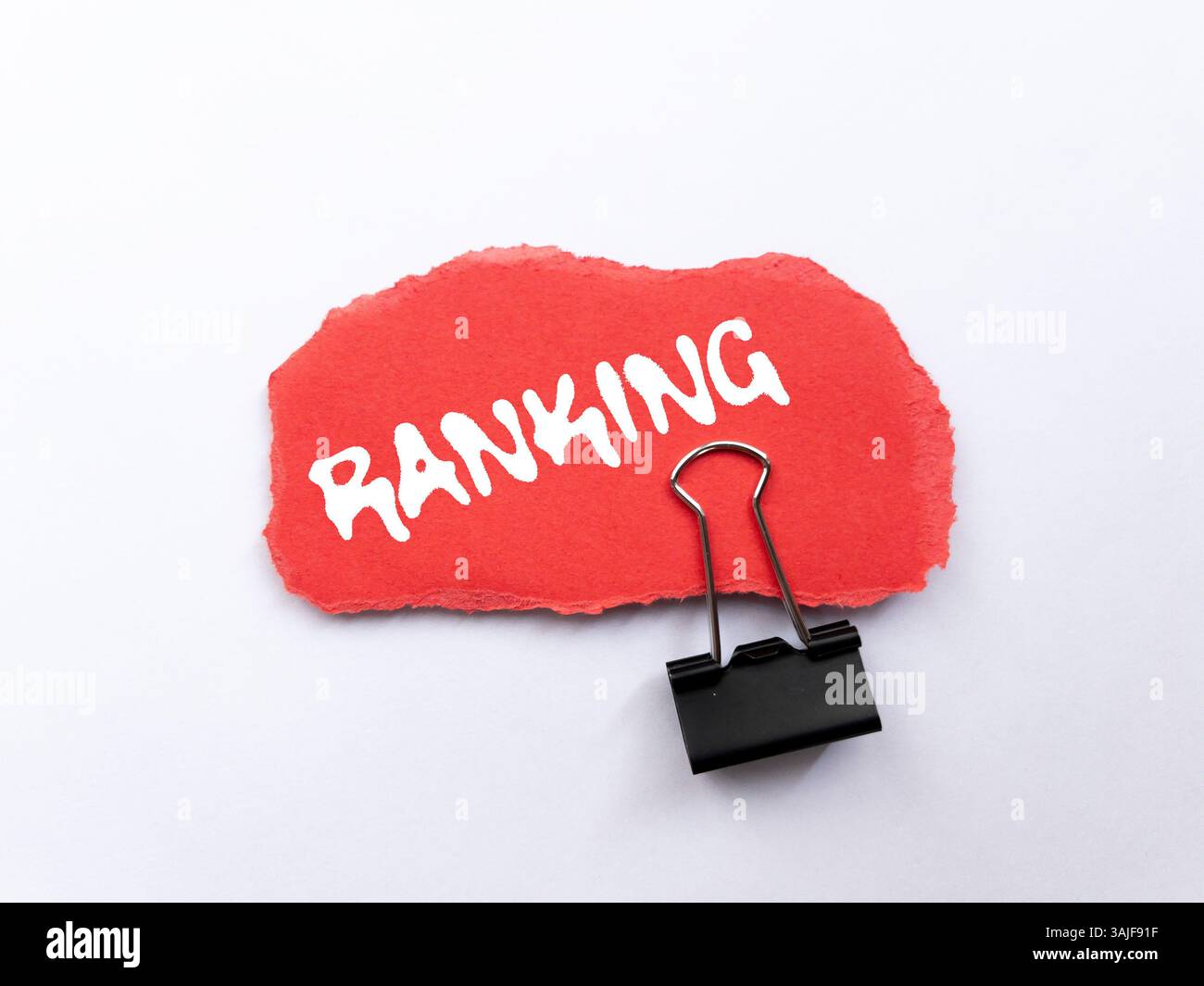 Ranking message written on ripped torn red paper piece on white background. Conceptual ranking ...