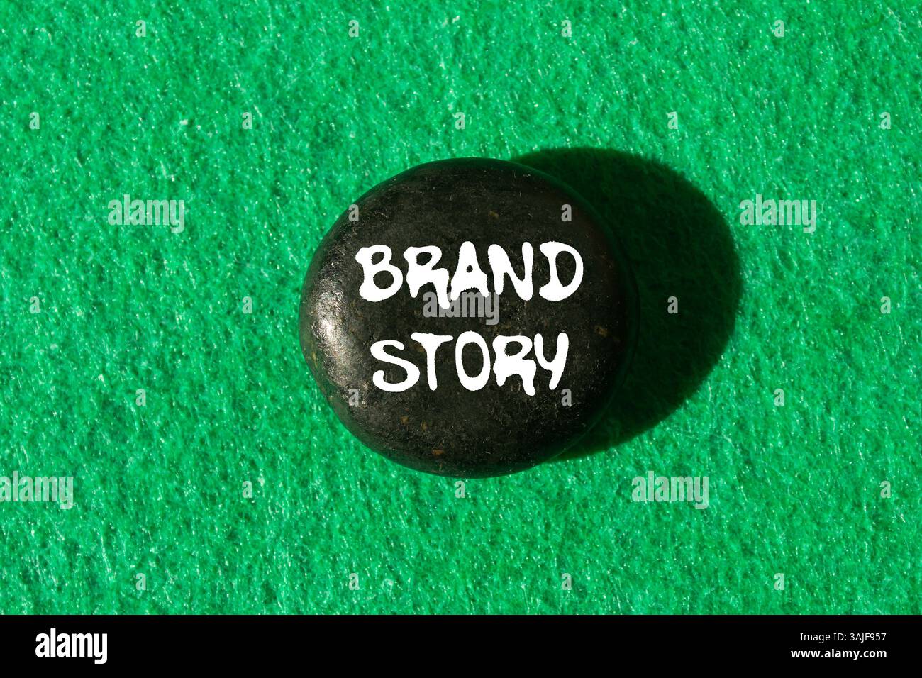 Brand story message written on black stone on green background ...