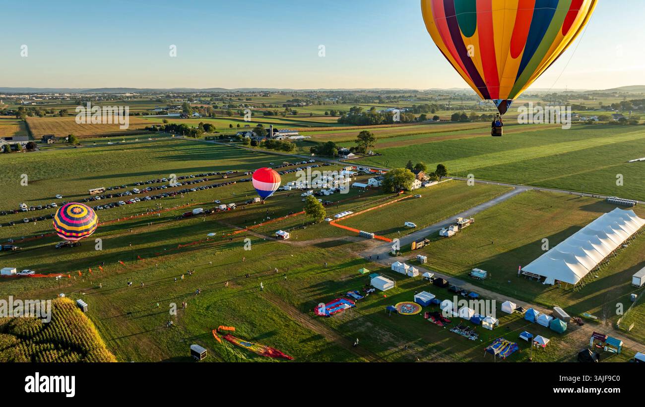 Hot air balloons take to the sky above a picturesque countryside during ...