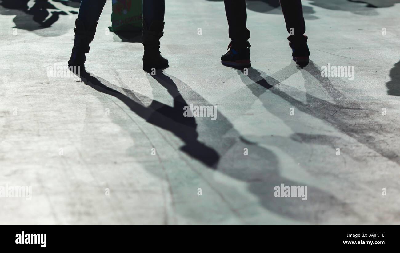Elongated shadows of people walking on a gray floor Stock Photo - Alamy