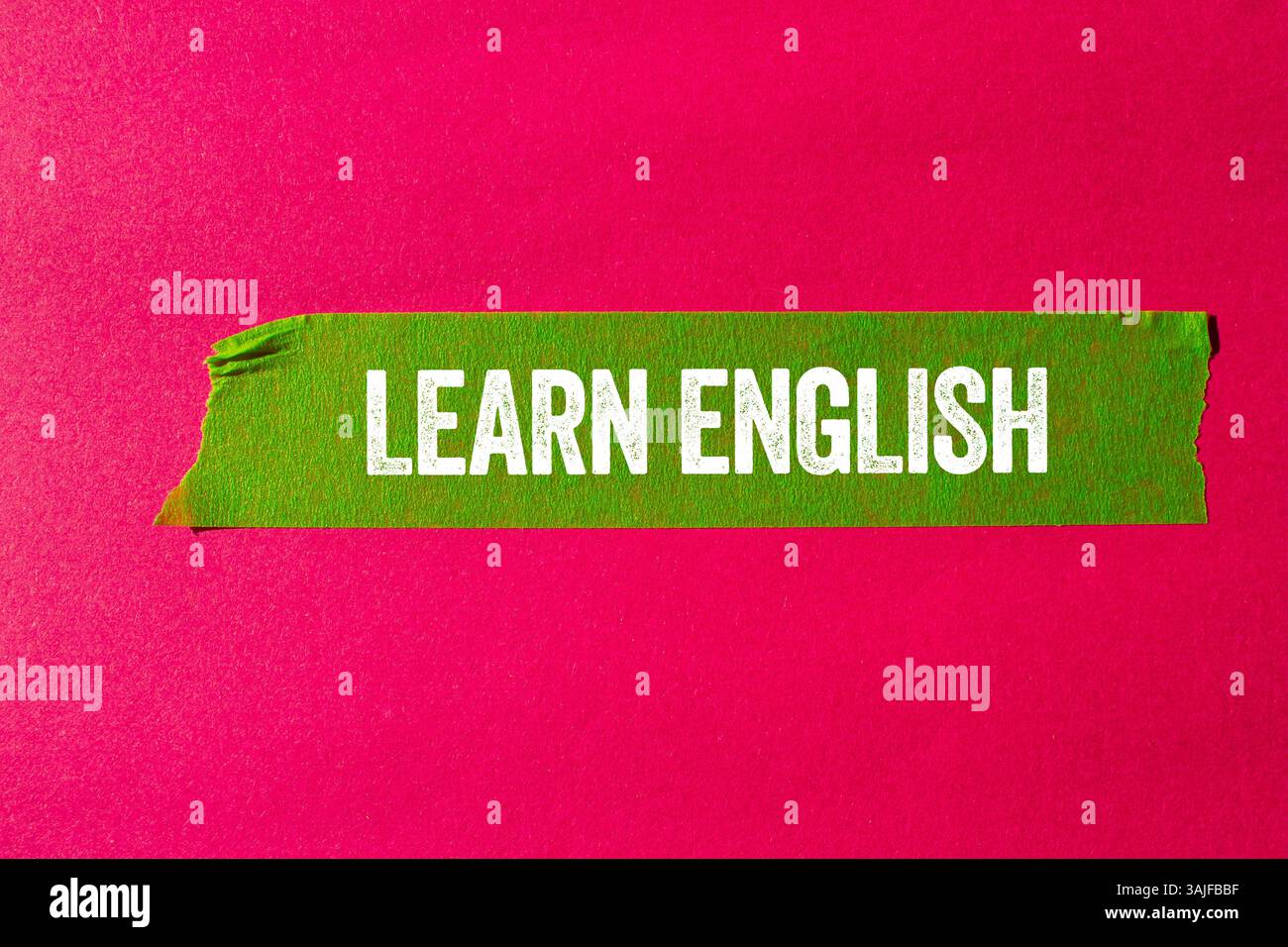 Learn english message written on ripped torn green paper tape on pink background. Conceptual ...