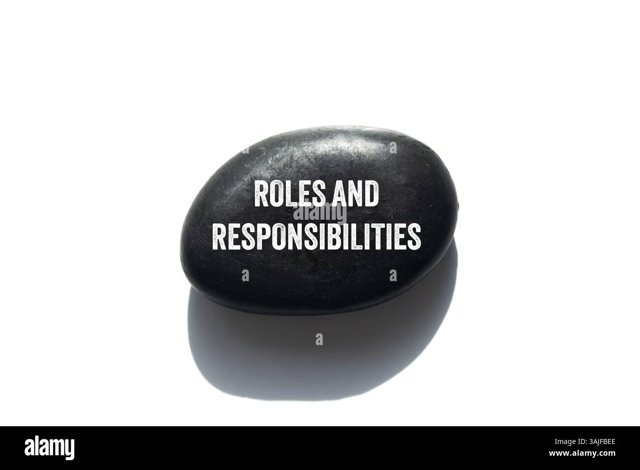 Roles and responsibilities message written on black stone on white ...