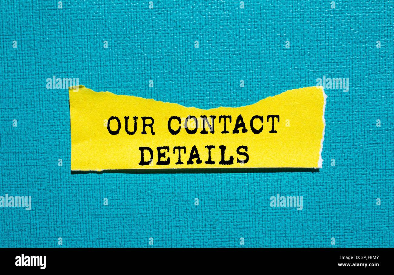 Our contact details message written on ripped torn yellow paper piece on blue background ...