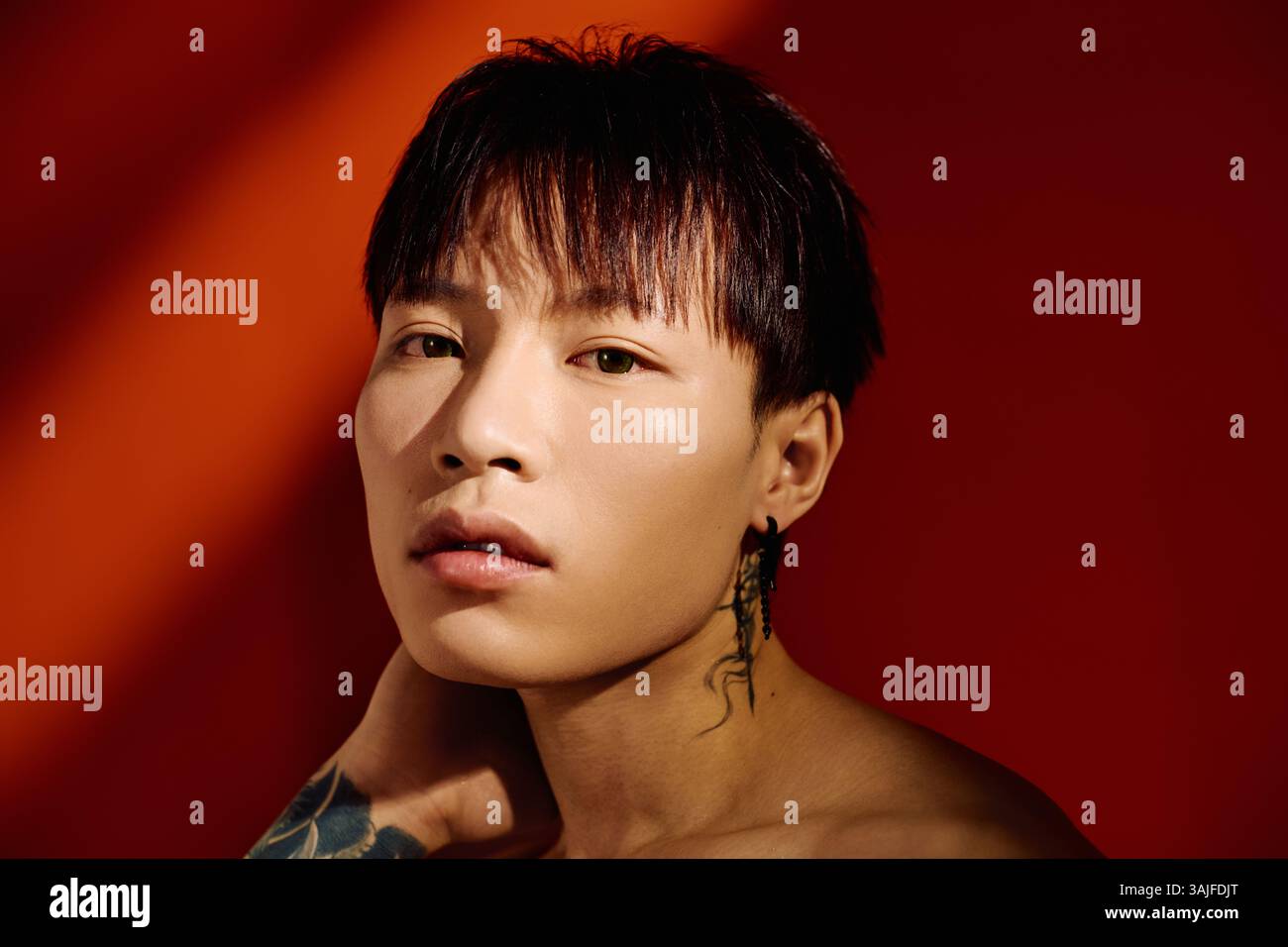 Charming asian man displays his unique style with an artistic backdrop ...