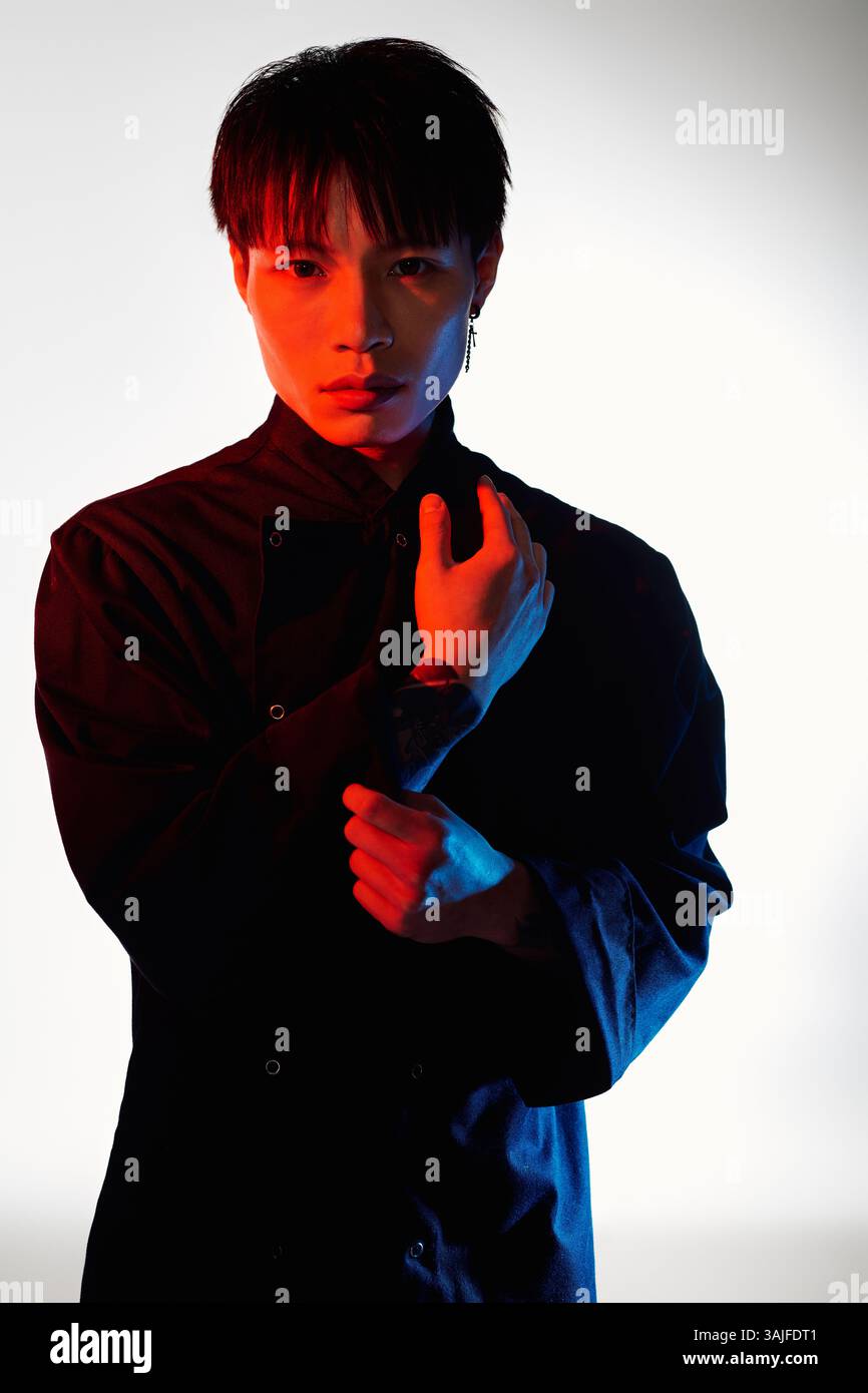 A young man displays his charm and style under dramatic lighting ...