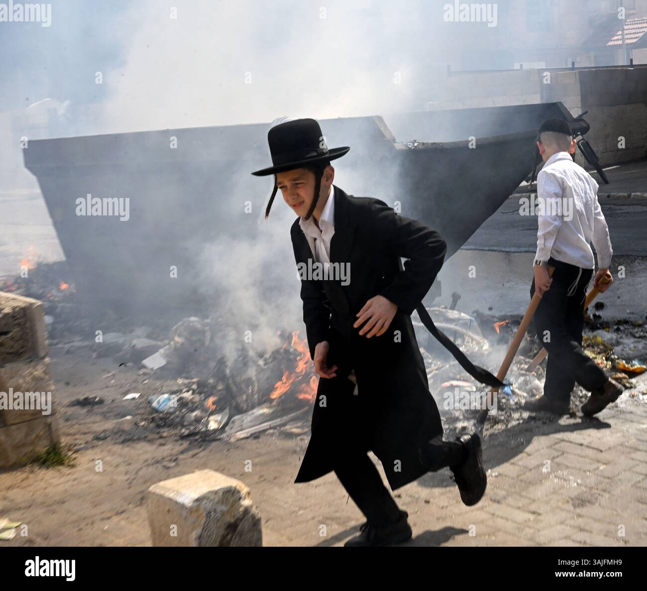 An Ultra-Orthodox Jewish youth runs in smoke from burning leavened ...