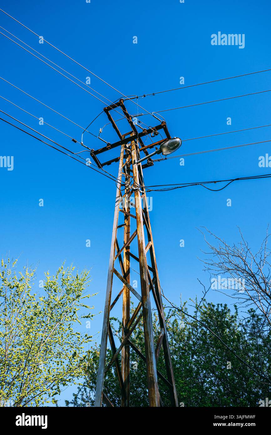 Old metallic lamp post with street light and messy electrical wires ...