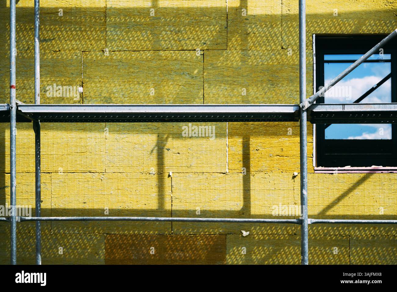 Mineral wool house insulation. Construction site with scaffolding and ...