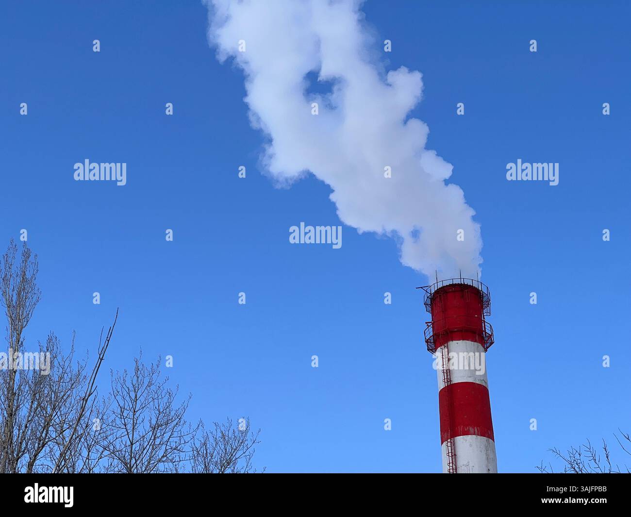 Red and white industrial smokestack emitting vapor Stock Photo - Alamy