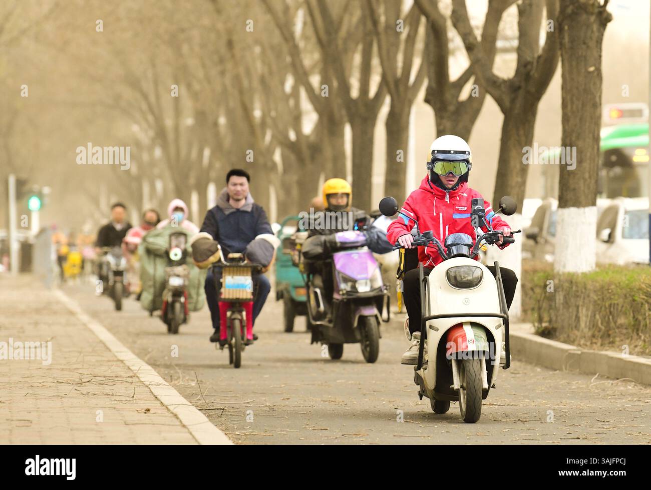 HOHHOT, CHINA - APRIL 11, 2025 - Citizens ride during windy and dusty ...