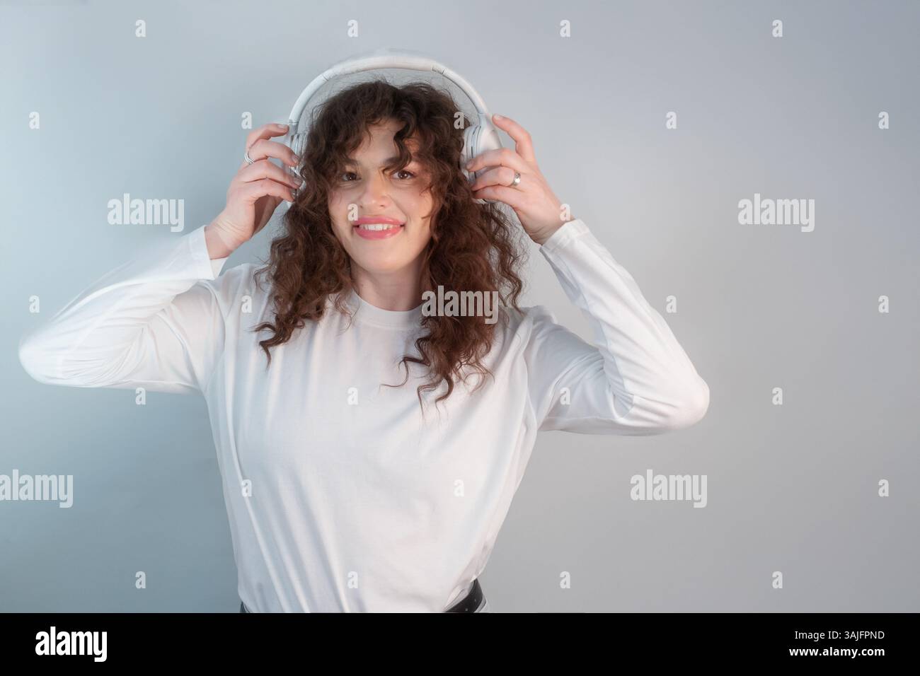 DJ woman with curly hair dancing and singing, wearing wireless ...
