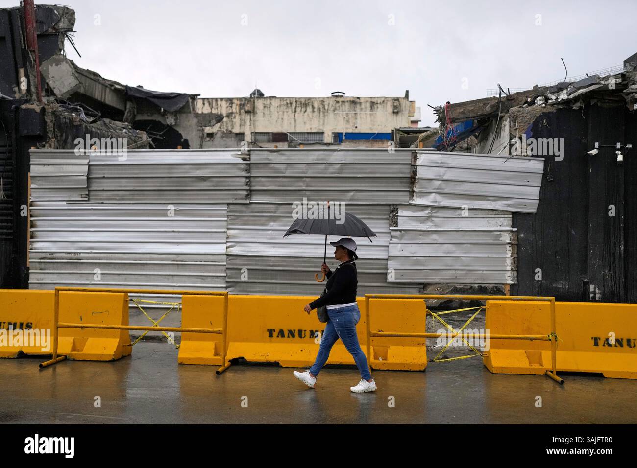 A woman walks past the rubble of Jet Set nightclub days after its roof ...