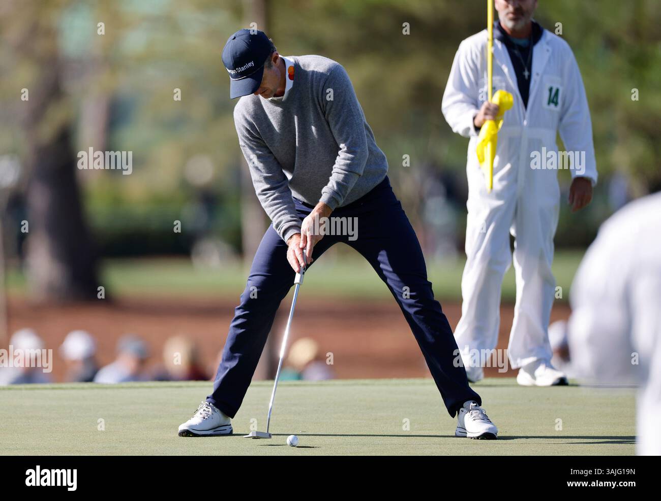 Justin Rose of England taps in a putt on the third hole during round ...