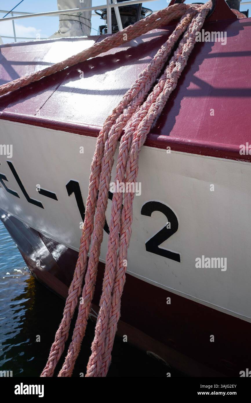 A boat with the numbers 12 and 2 on it. The rope is tied to the boat ...