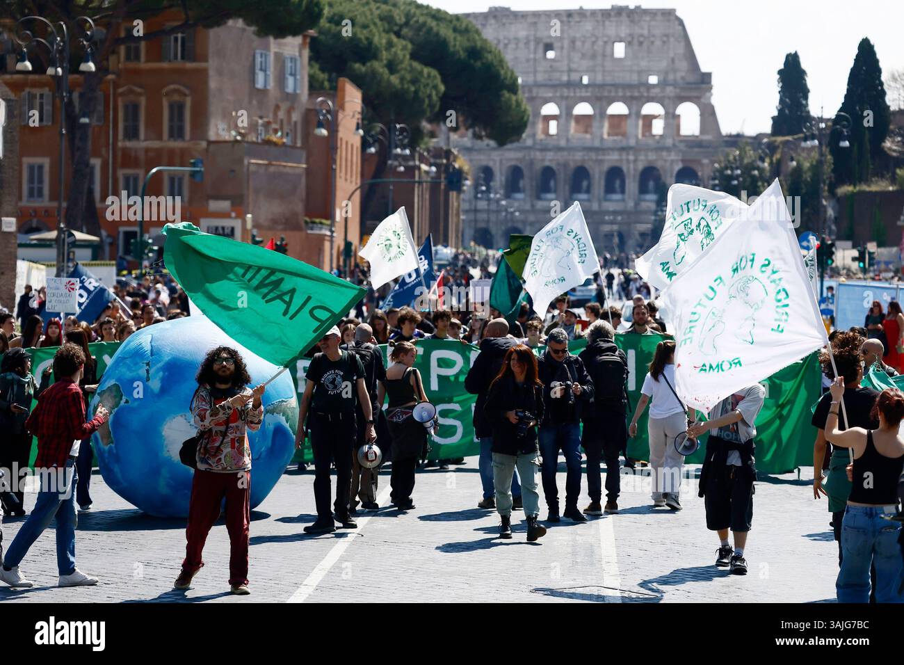 People march past the ancient Colosseum, background, during a Friday ...