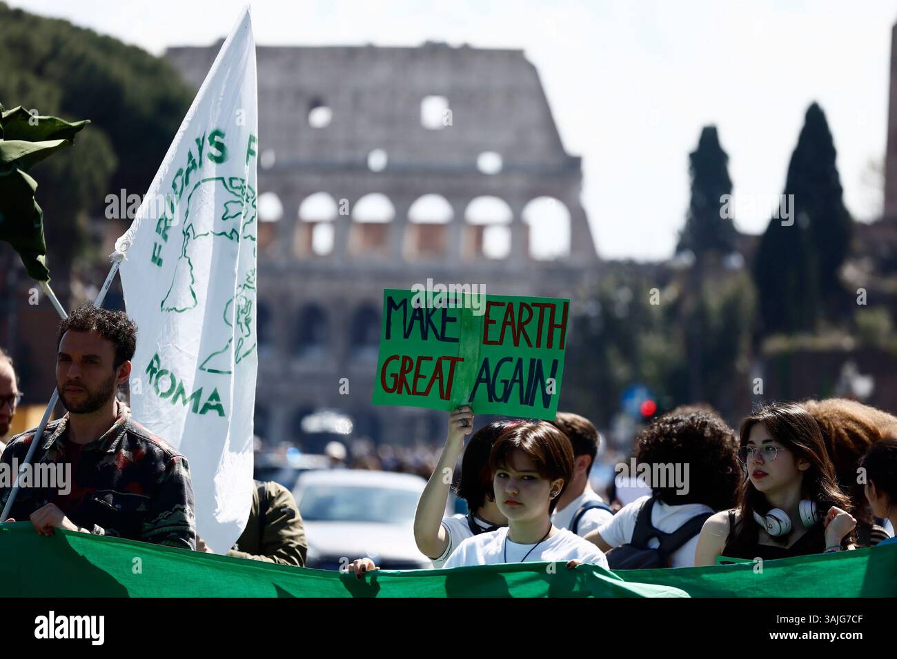 People march past the ancient Colosseum, background, during a Friday ...
