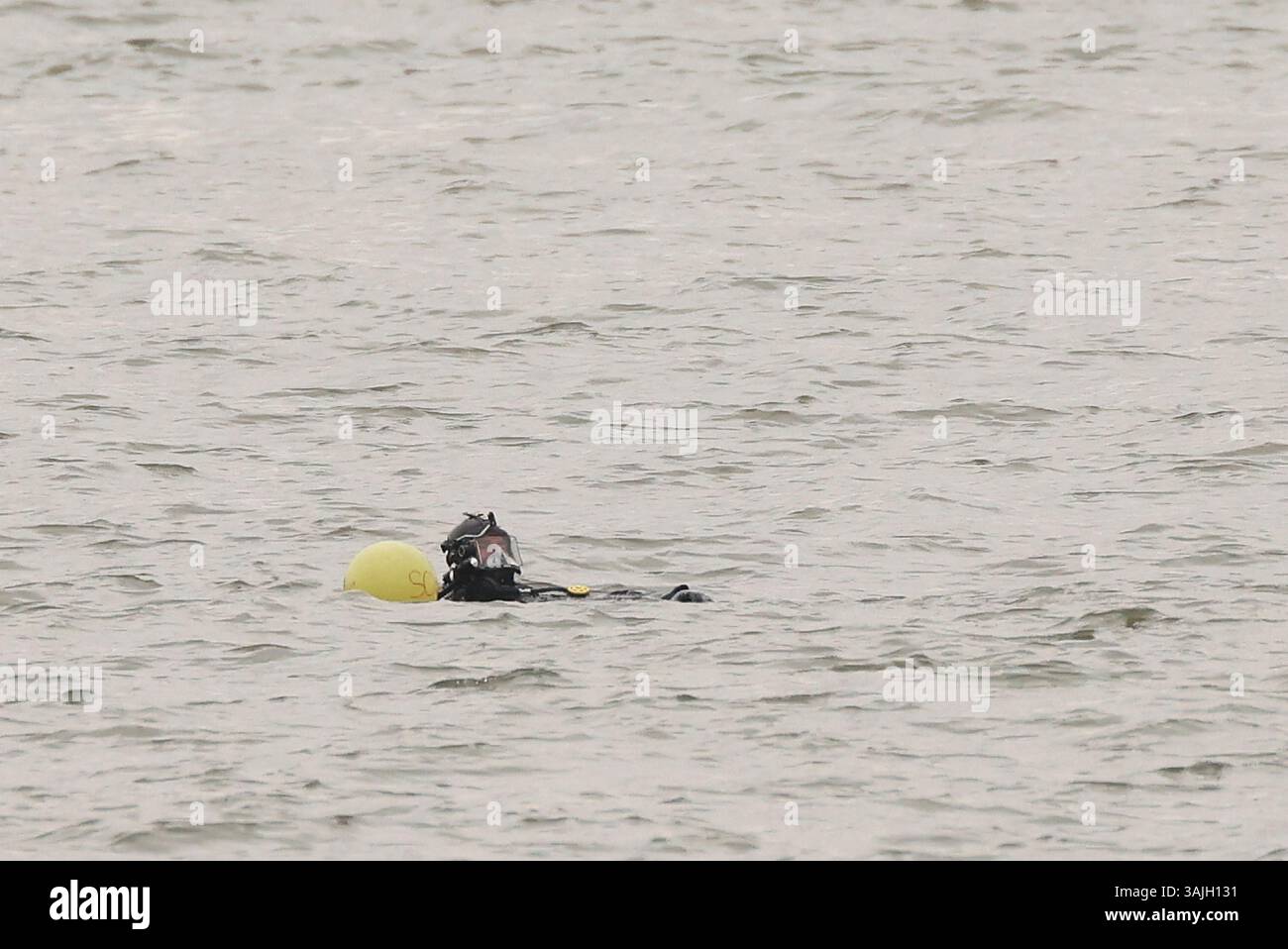 A New York Police Department scuba team diver prepares to search ...