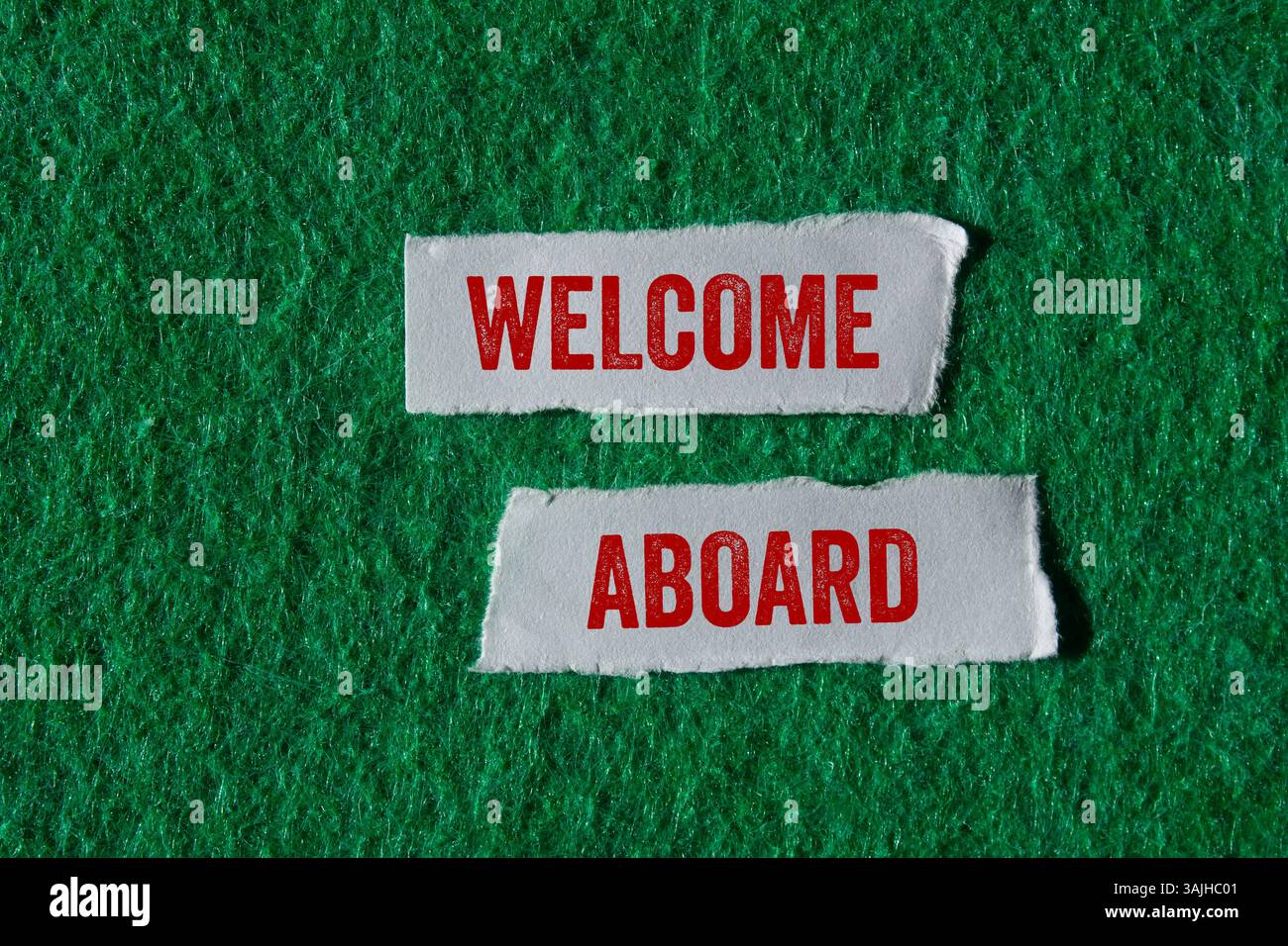 Welcome aboard message written on ripped torn paper pieces on green ...