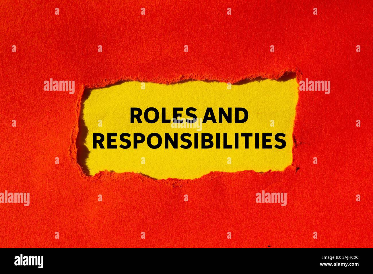 Roles and responsibilities message written on ripped torn red paper on yellow background ...