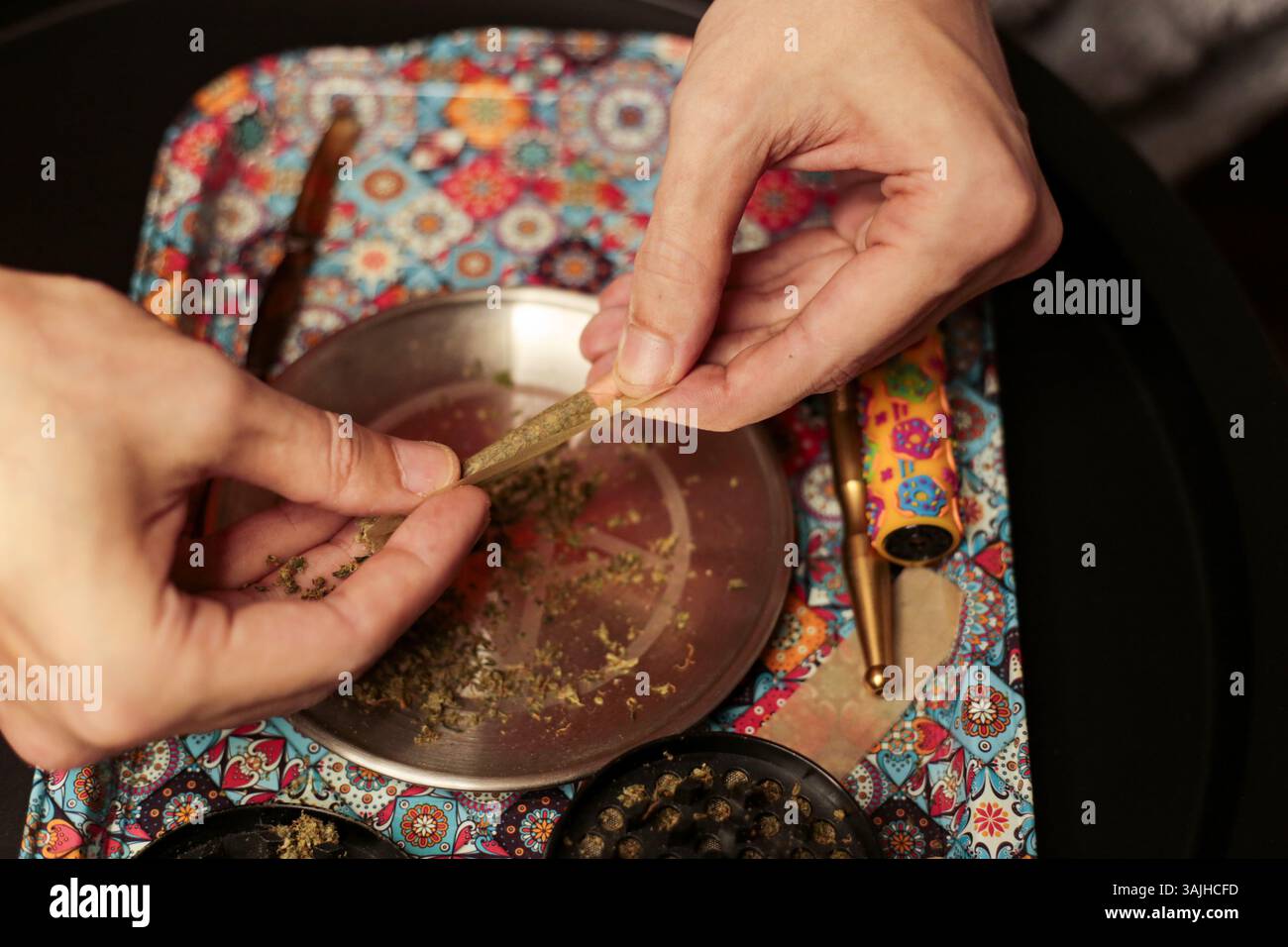 Hand Rolling a Joint with Grinder and Tray Stock Photo - Alamy