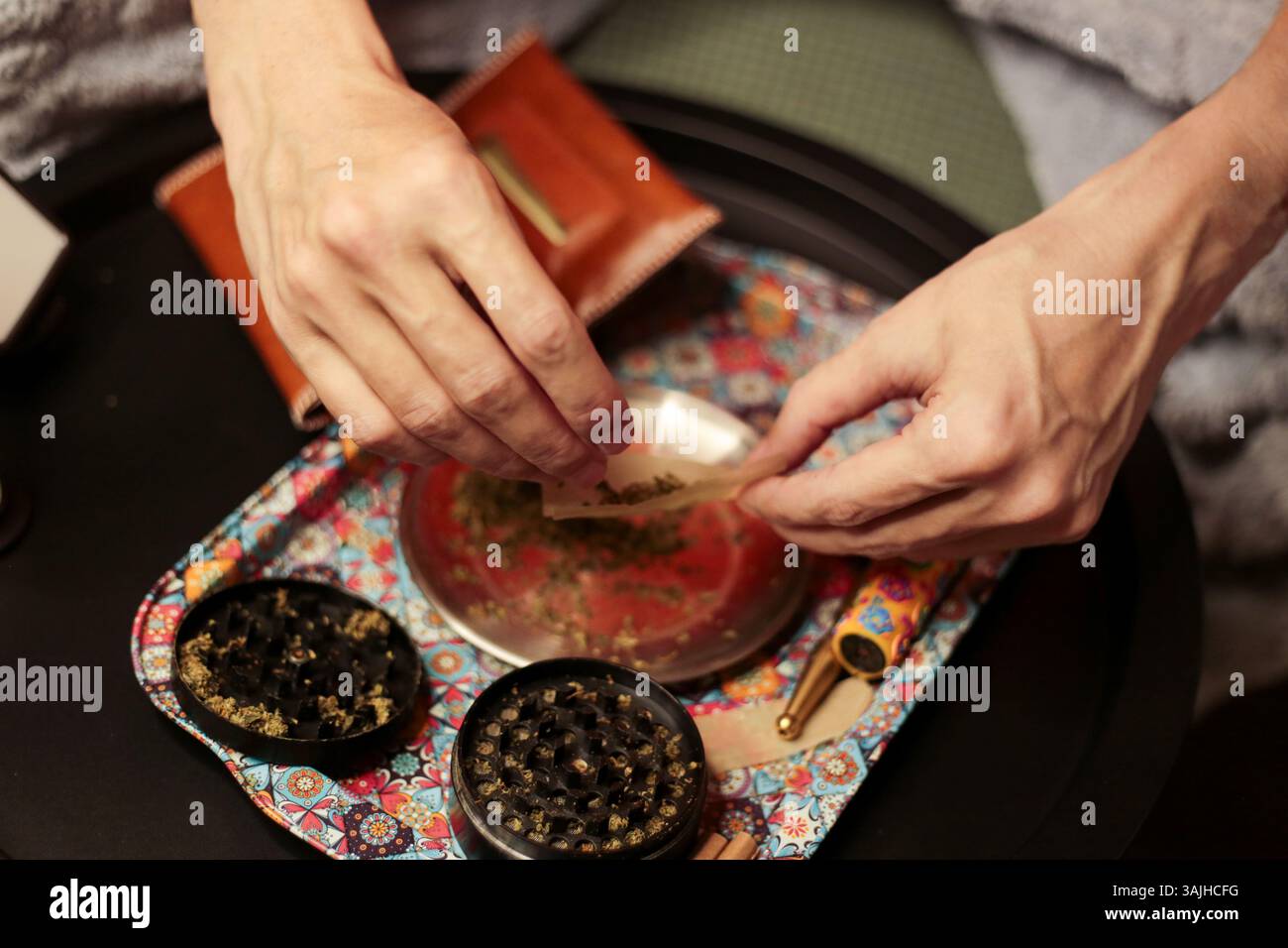 Hand Rolling a Joint with Grinder and Tray Stock Photo - Alamy