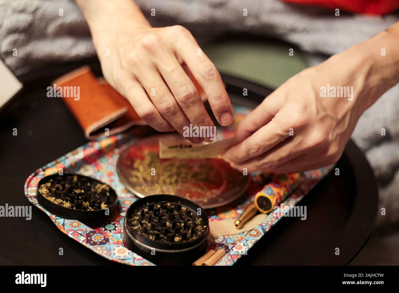 Hand Rolling a Joint with Grinder and Tray Stock Photo - Alamy