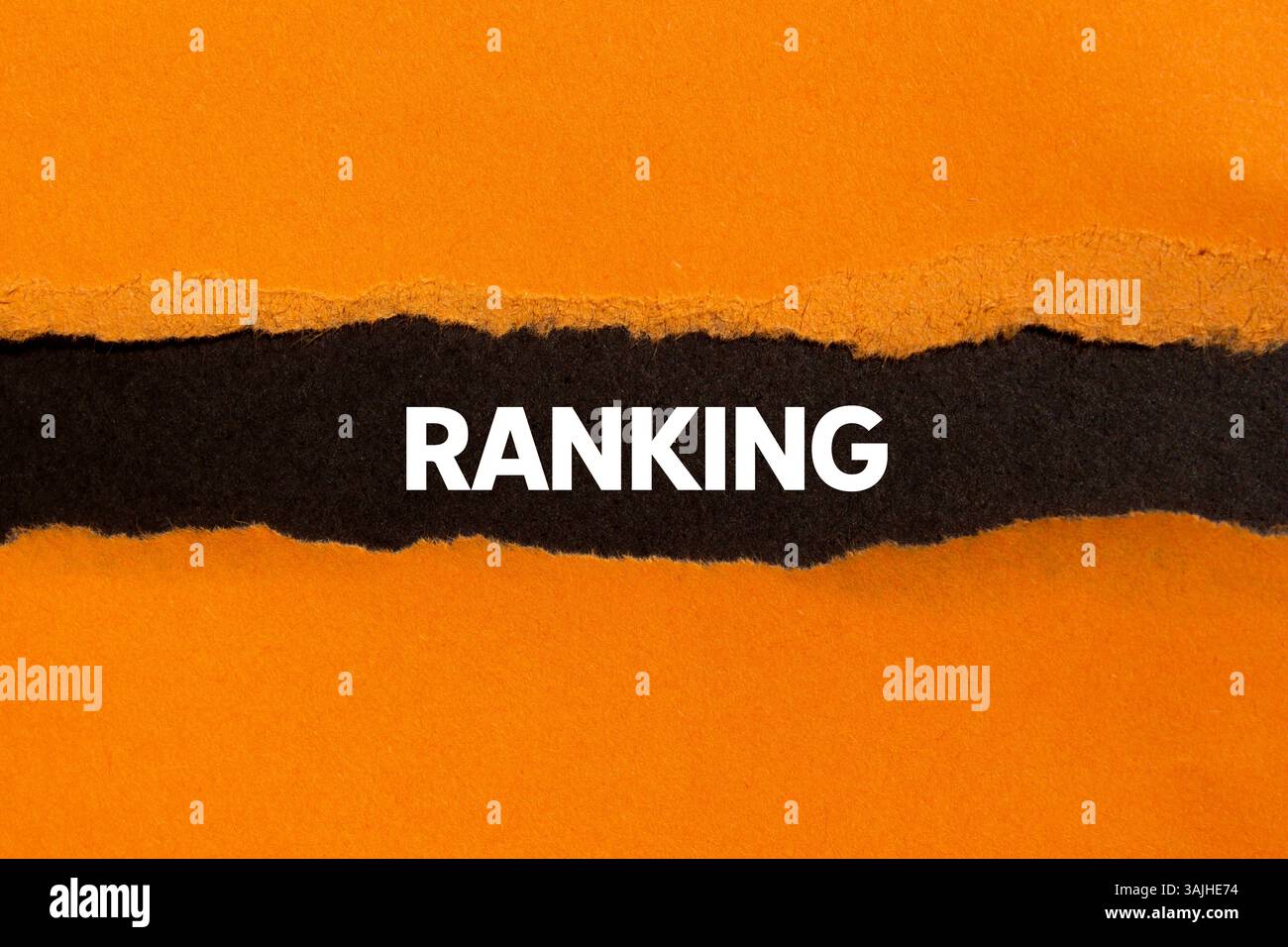 Ranking message written on ripped torn orange paper on black background ...