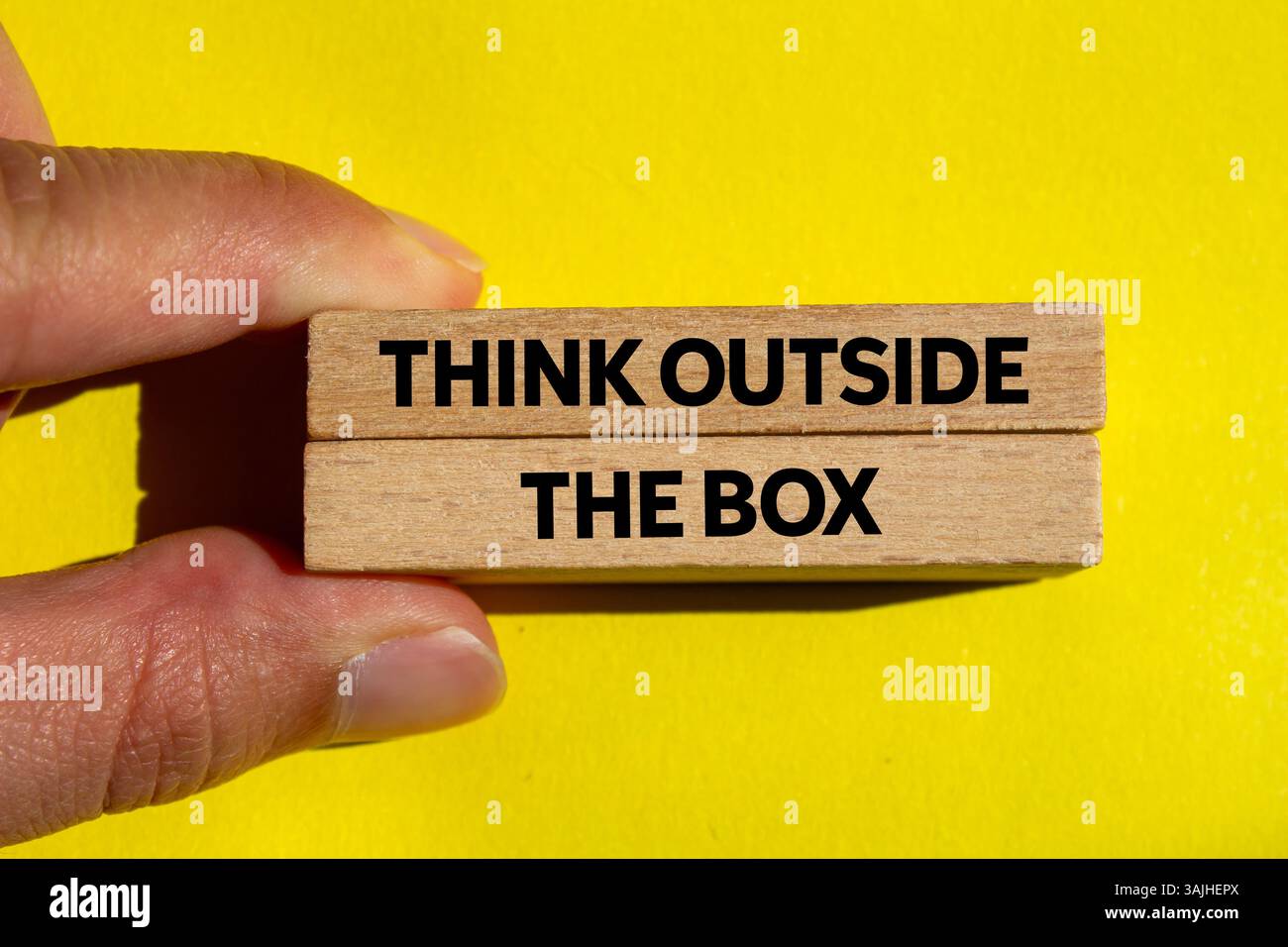 Think outside the box message written on wooden blocks on yellow ...