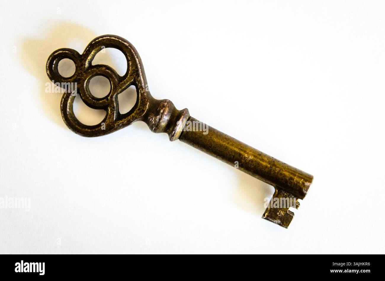Antique Brass Skeleton Key on White Background, shown at an angled side ...