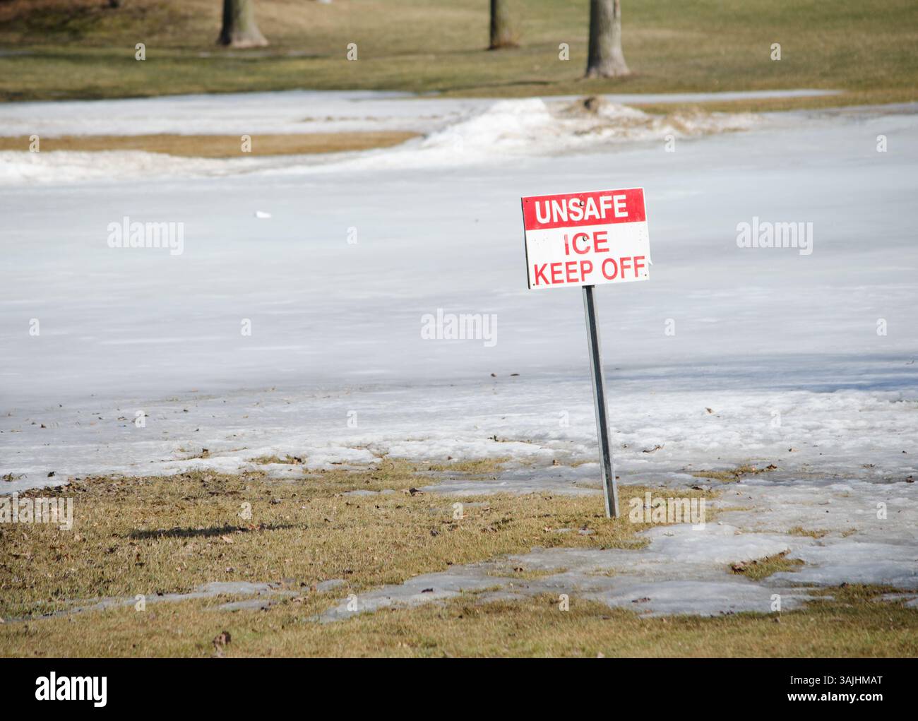 view of a warning sign to Keep Off Unsafe Ice showing melted surface ...