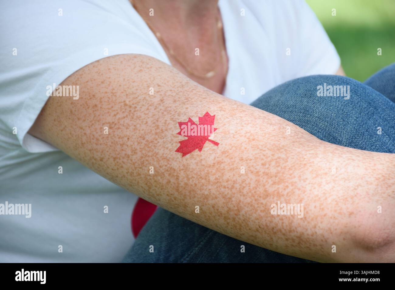 Red maple leaf temporary tattoo on woman's arm on Canada Day Stock Photo - Alamy