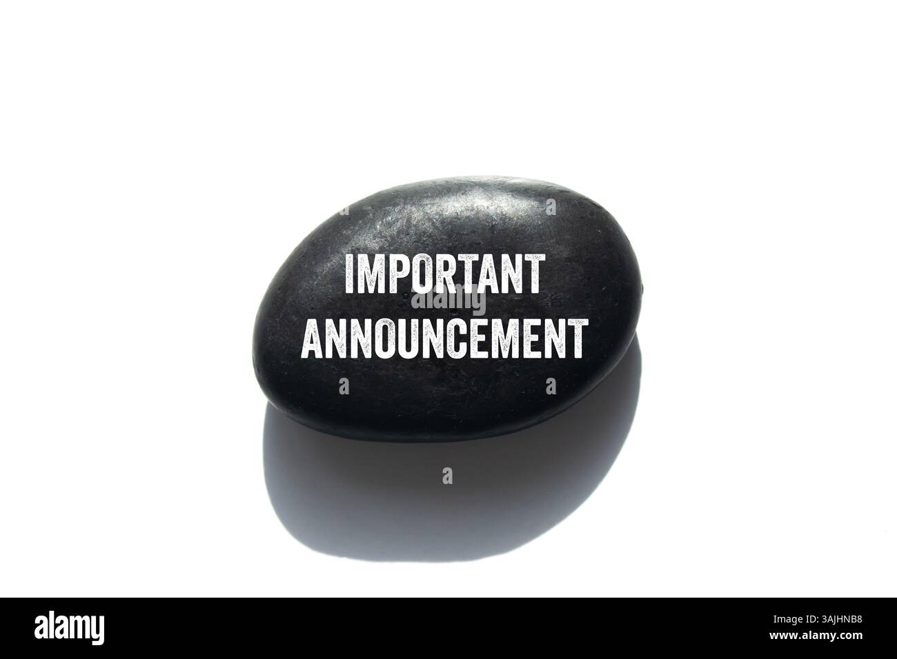 Important announcement message written on black stone on white ...