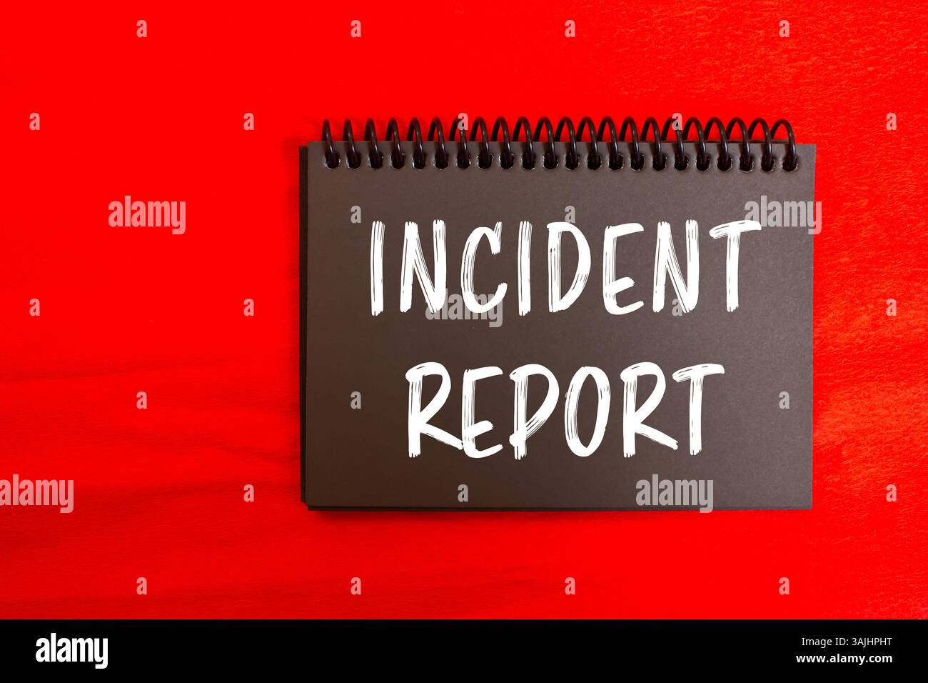 Incident report message written on black notebook page on red ...