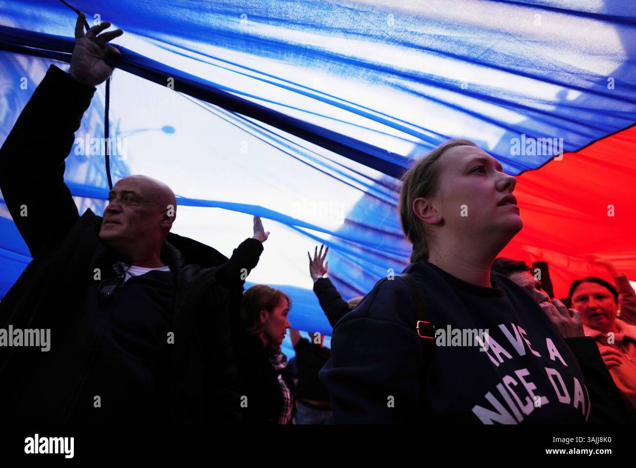 People hold a giant Serbian flag ahead of a big counter-opposition ...
