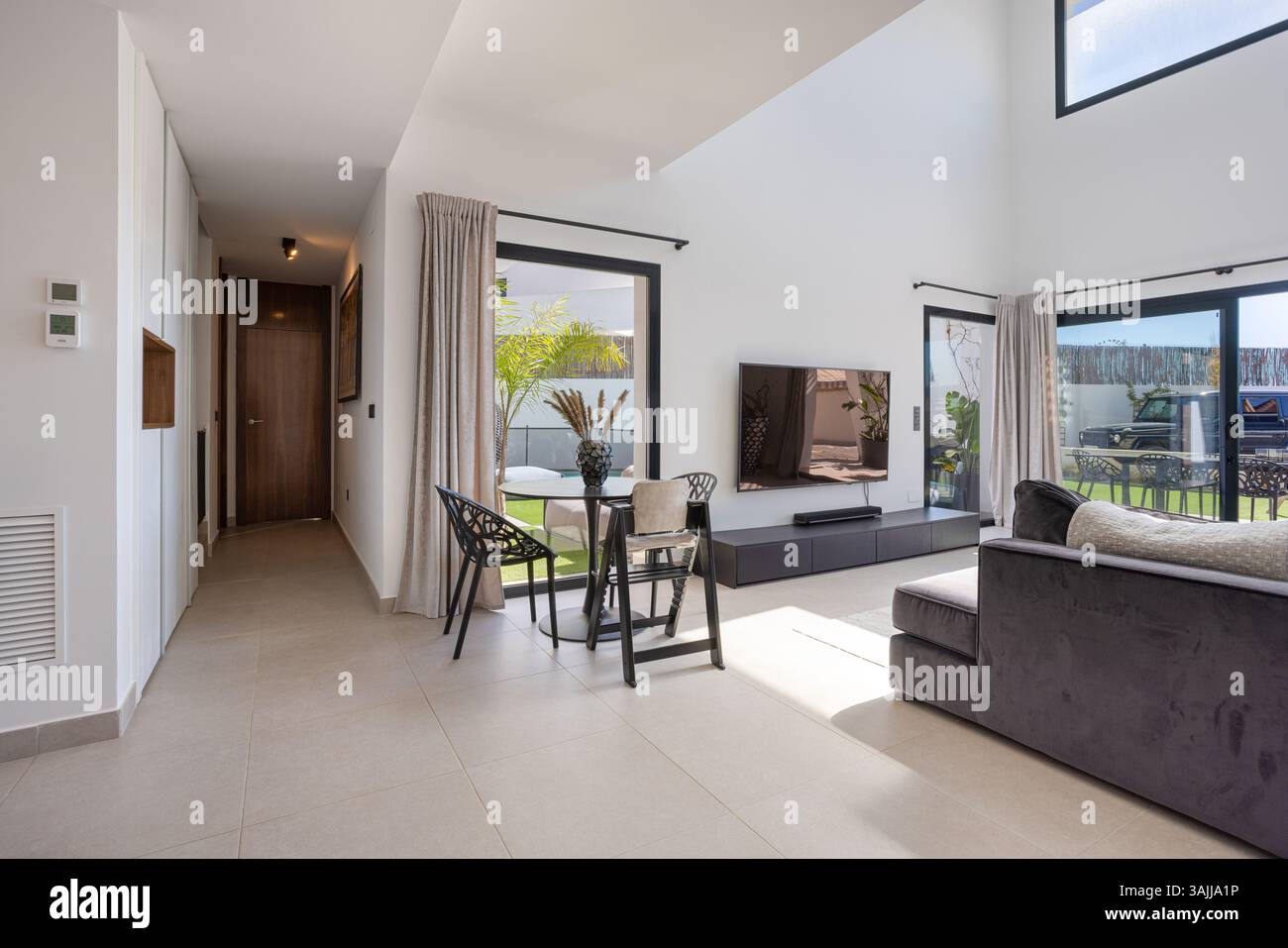 Open hallway leading to a glass dining area with views of the garden ...